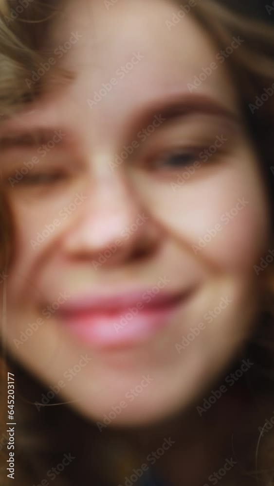 Vidéo Stock Close Up Of The Face Of A Curly Haired Girl Who Takes Off