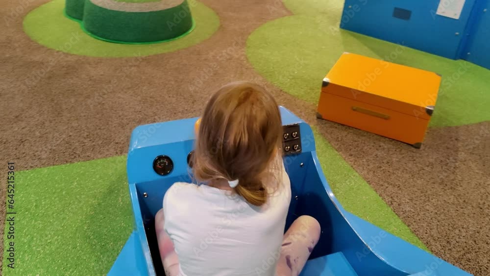 Cute 7 year old girl playing and pretend steering wooden toy airplane ...
