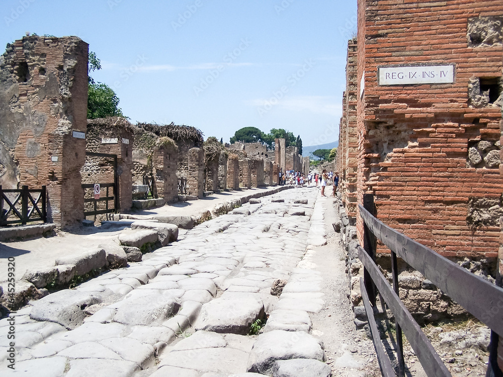 Stone paved road and footpath, with stepping stones to cross the road ...