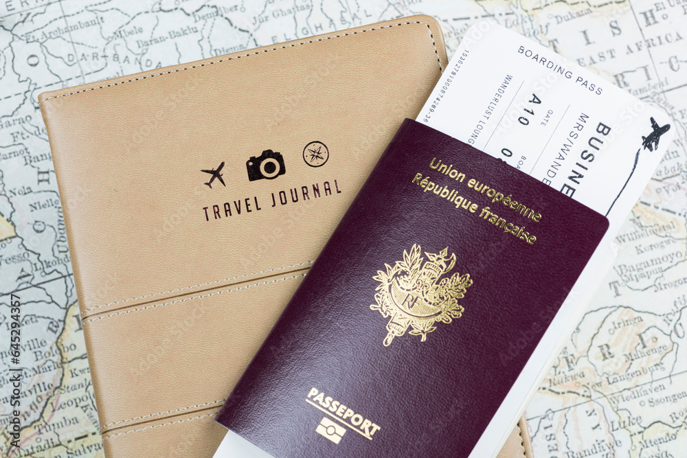 French and European passports, a boarding pass, and a travel book, all ...