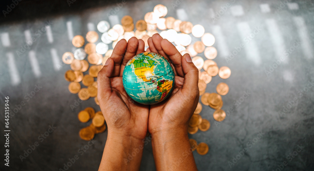 Globe in hand with gold coins background. money makes the world go ...