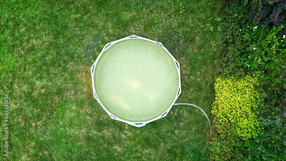 Aerial, drone top down view on the green water in the garden pool ...