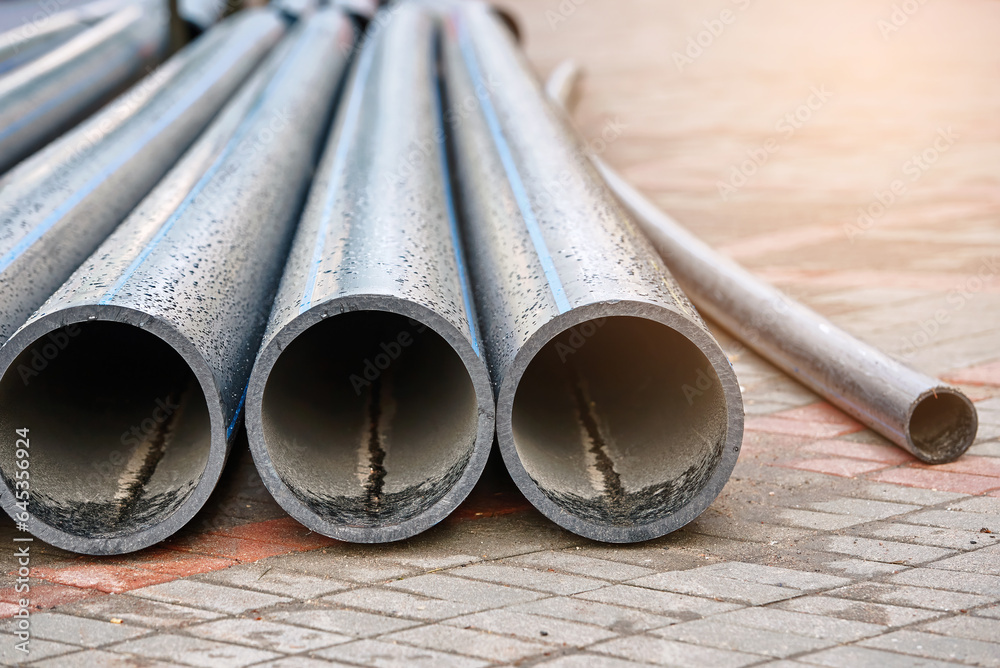 Pipe for water supply on pavement. Black HDPE polyethylene pipe. HDPE ...