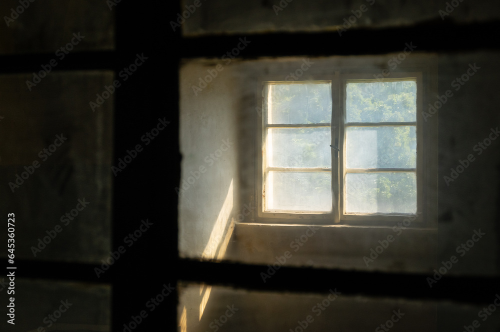 Sunlight entering a dark spooky room through filthy windows in an ...
