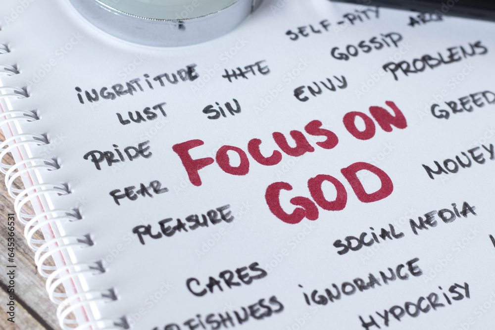 Focus on God, handwritten words in notebook with magnifying glass ...