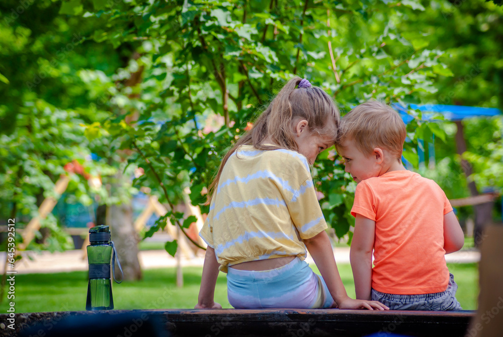 SONY DS Younger brother and older sister are sitting on bench and ...