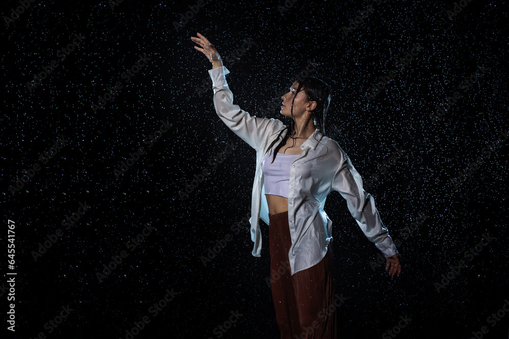 young woman in the rain, getting wet through, wet clothes and water ...