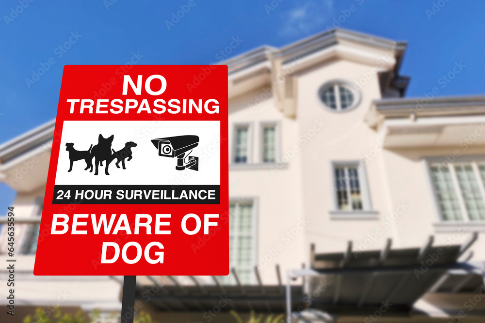 A warning sign in front of a house, protected by CCTV and guard dogs ...
