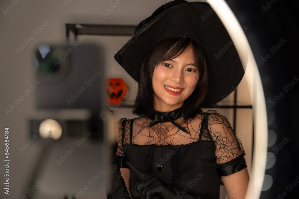 Female influencer wearing witch costume and live streaming at home. She ...