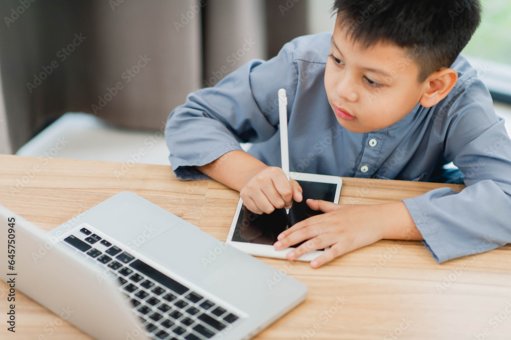 Little Asian boy student using computer laptop and tablet learning ...