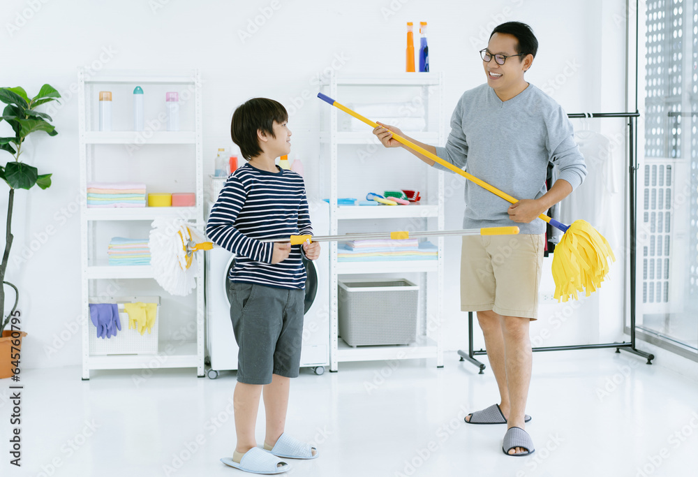 Happy Asian family cleaning house and having fun. Father dancing and ...