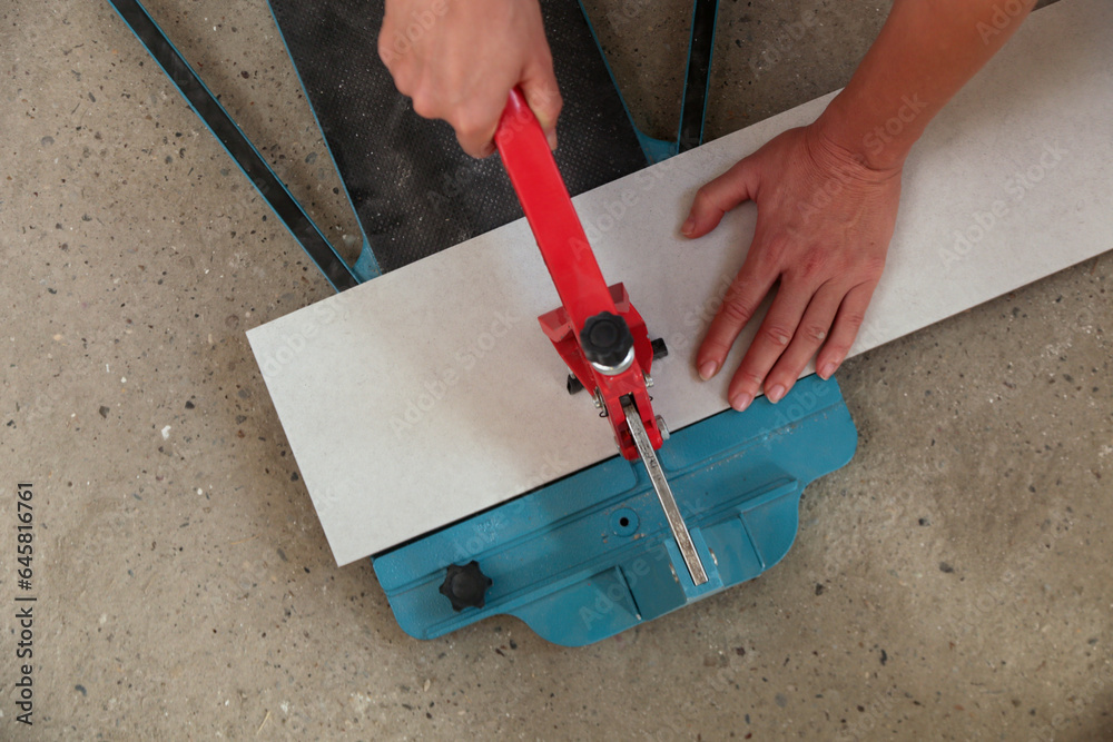 Cutingt tiles with a standard manual tile cutter. Process of ...