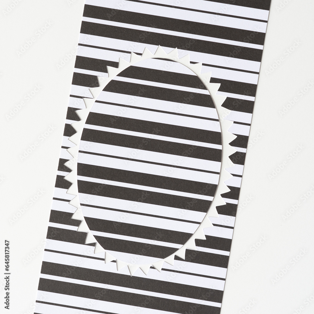 black and white paper with stripes and machine-cut oval and fancy frame ...