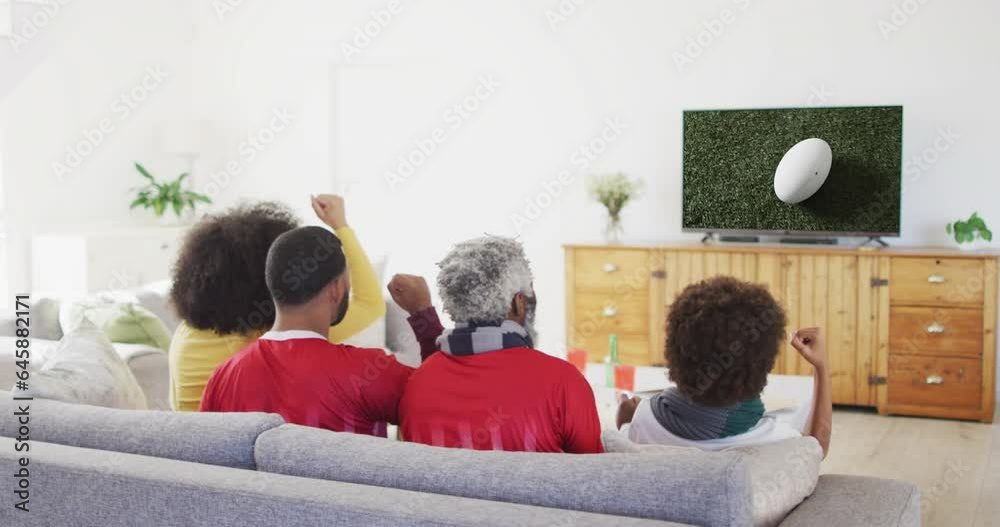 Biracial family watching tv with rugby ball at stadium on screen Stock ...