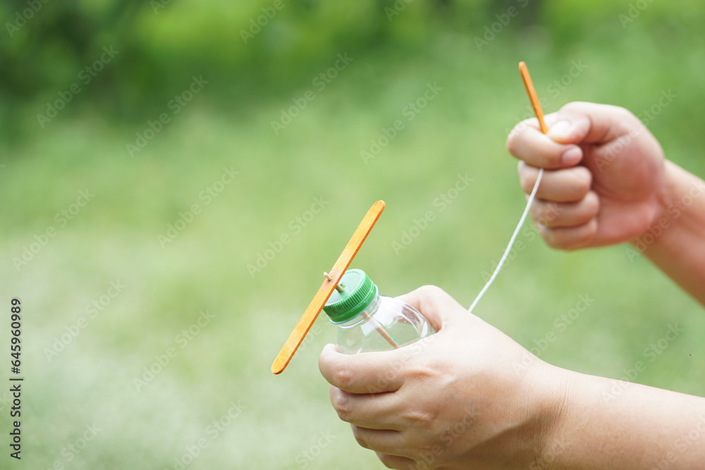 Close up hands hold DIY toy made from plastic bottle, rope and ice ...