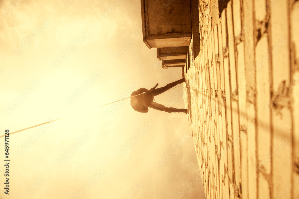 Silhouette of police officer in tactical gear descending from a height ...