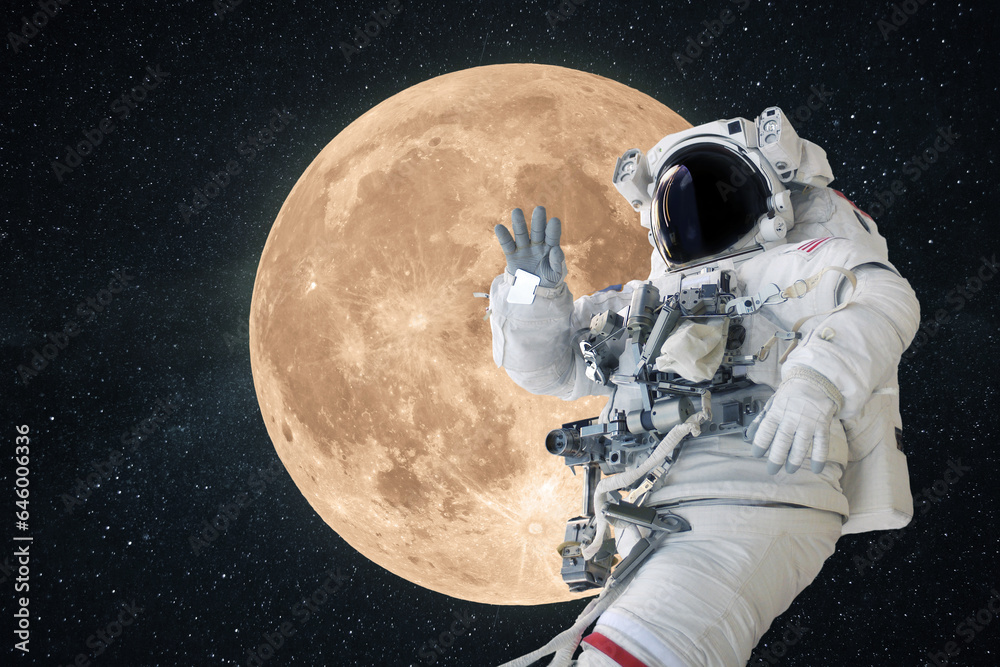 Space man astronaut greets and waves his hand in space on a background ...