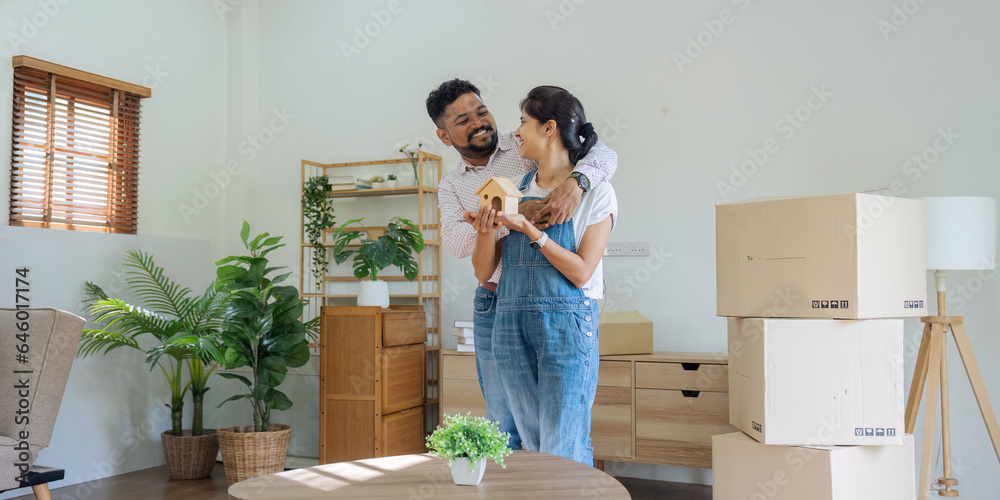 Foto de Married Indian couple owners holding house model moving in new ...