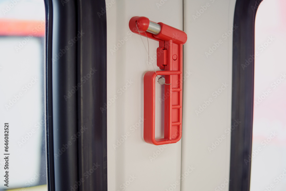 Hammer window glass breaker on the train, tram, bus and car. Red safety ...