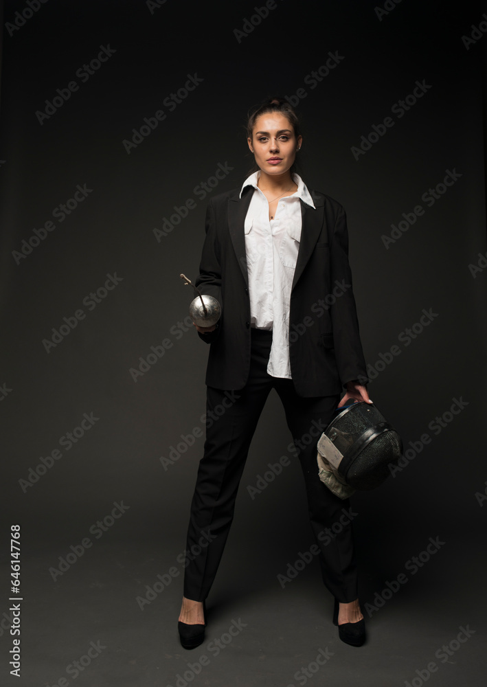 Business woman with a rapier and a fencing helmet. Confident girl in a ...