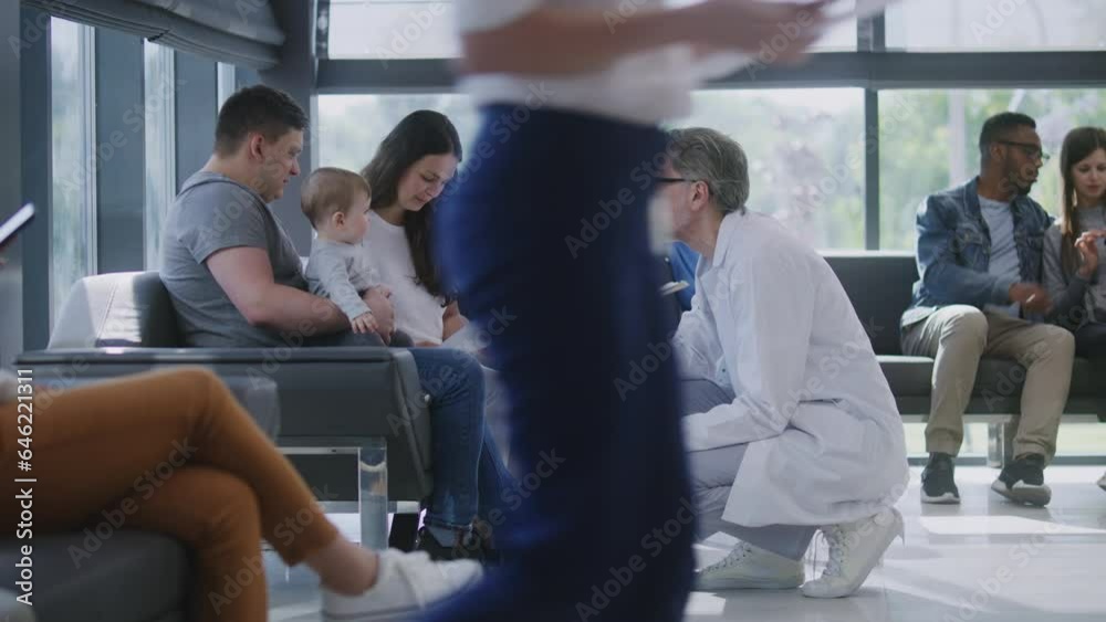 Diverse people sit on couches in clinic lobby area, wait for doctors ...