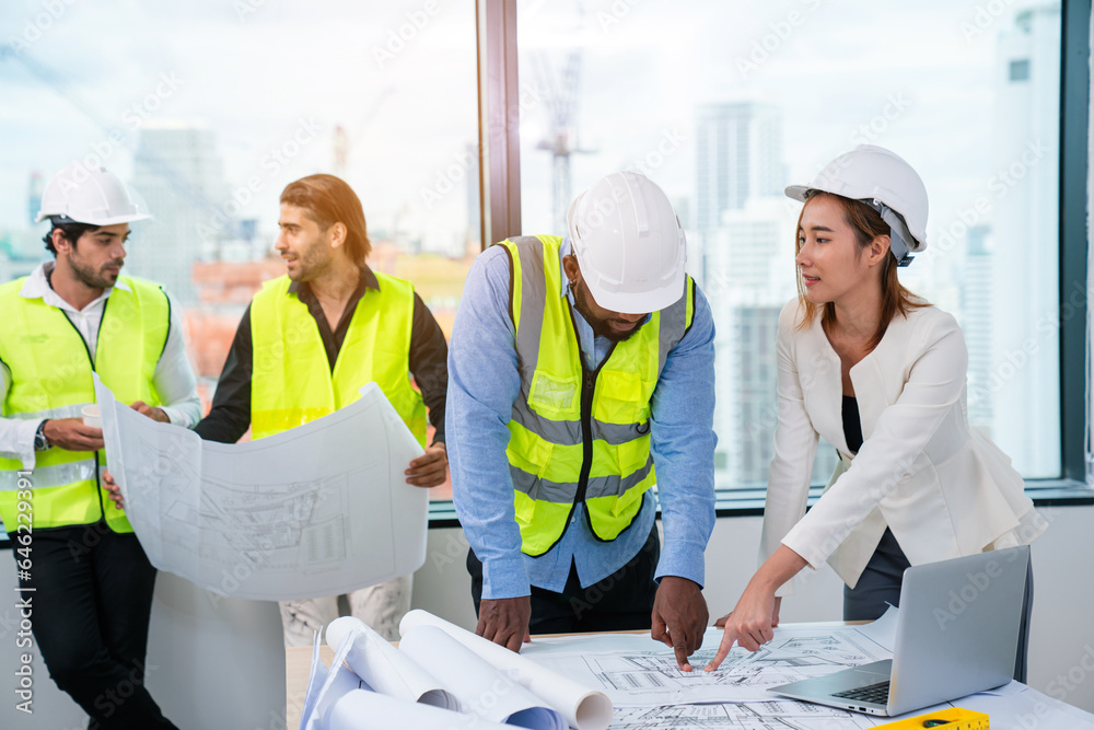 Architector and engineers with draft plan of building and laptop ...
