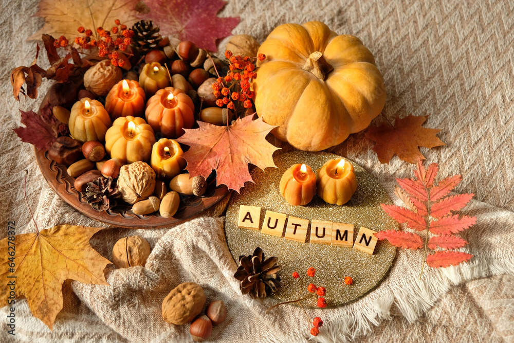 Autumn background. Burning decorative candles, acorns, nuts, dry leaves ...
