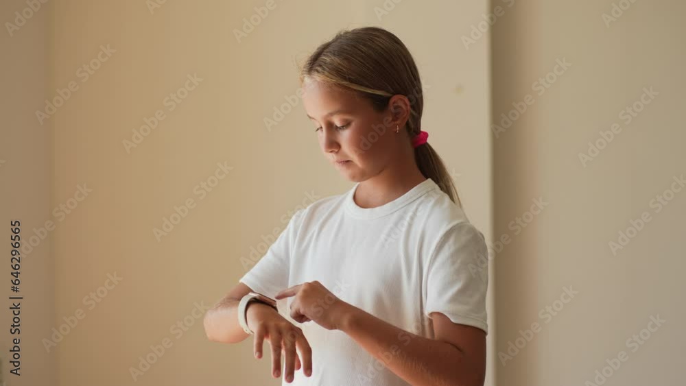 Portrait of pretty preteen girl using modern smart watch touching ...