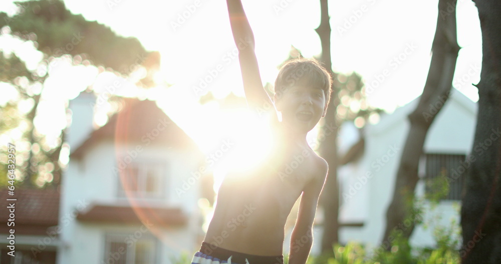 Boy raising arms in the sky clenching fists in victory and celebration ...