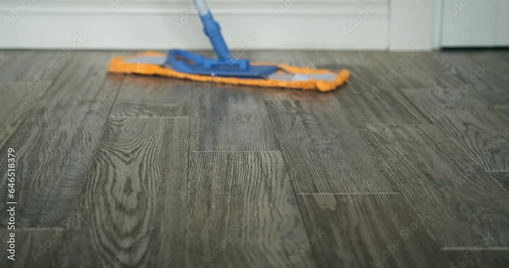 A mop deftly glides across the floor, efficiently removing dirt and ...