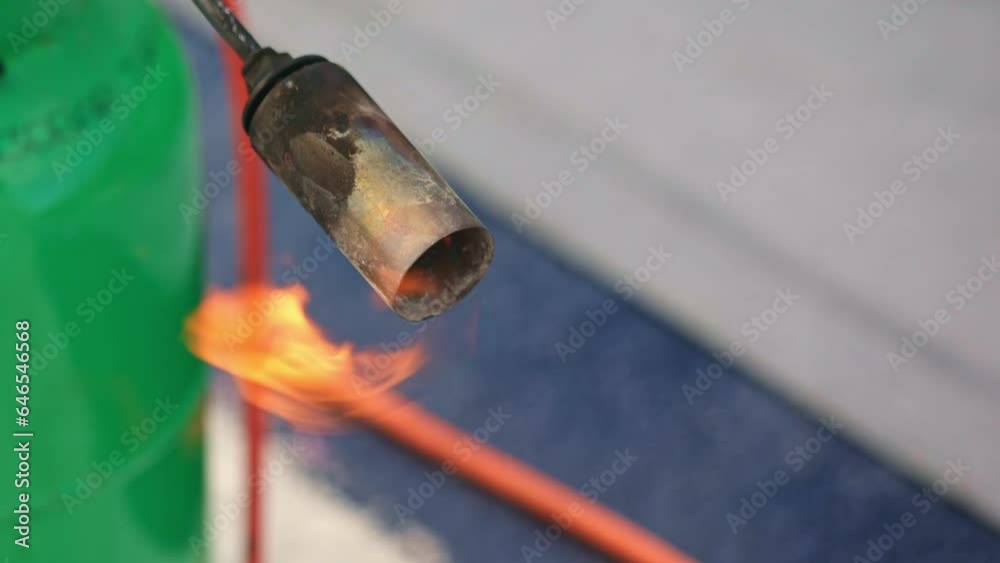Process of melting roll of tar onto the foundation of a house under ...