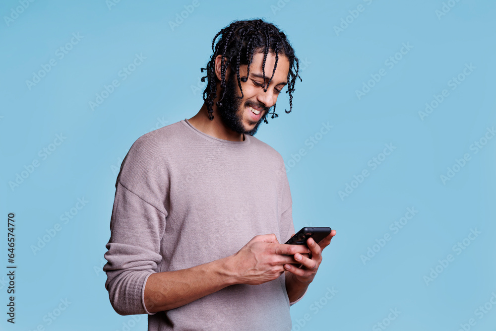 Smiling arab man texting on smartphone with happy face expression ...