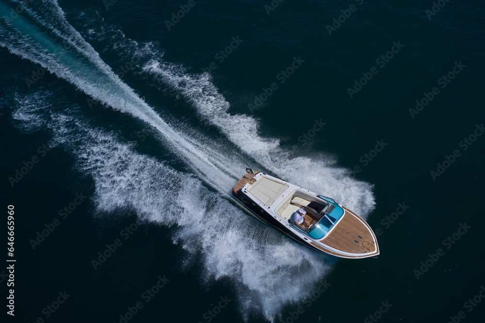 Foto de Luxury wooden big speedboat fast moving on dark water top view ...