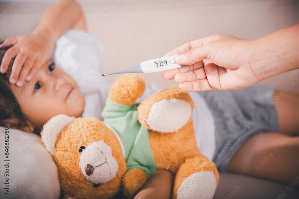 Sick kid. Mother checking temperature of her sick daughter with thermometer in mouth, child ...