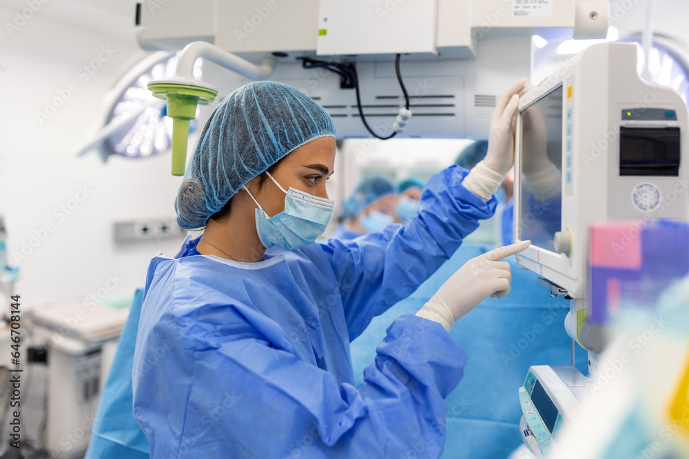 Anesthesiologist checking monitors while sedating patient before ...