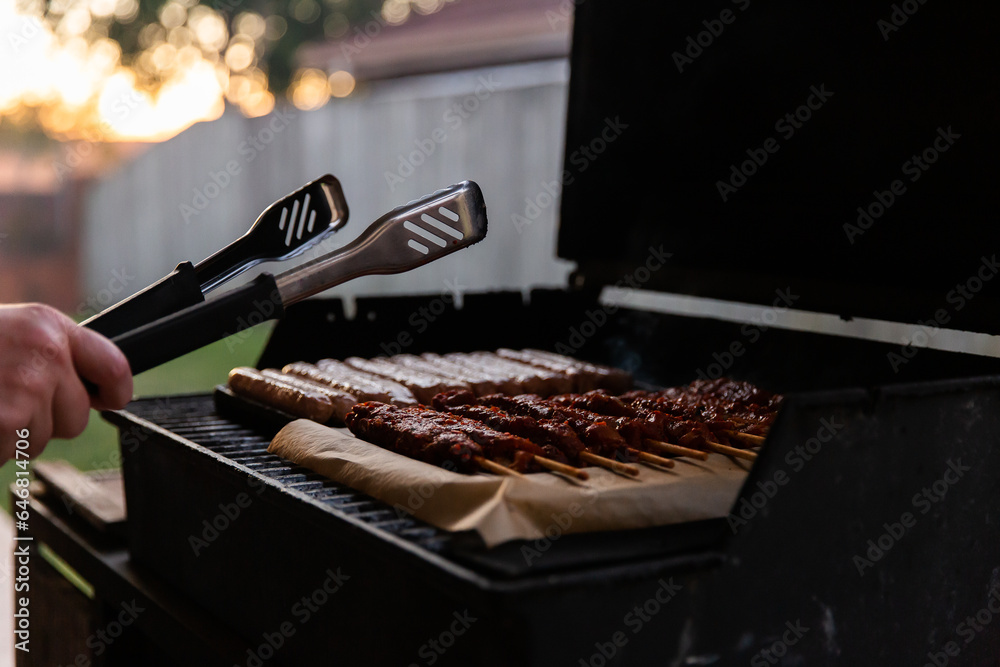 barbecue tongs and a backyard barbecue Stock Photo | Adobe Stock