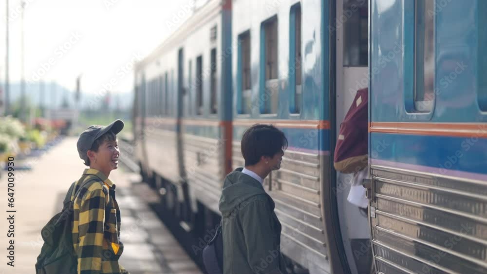 Group of Young Asian people get on the train at local railway station ...