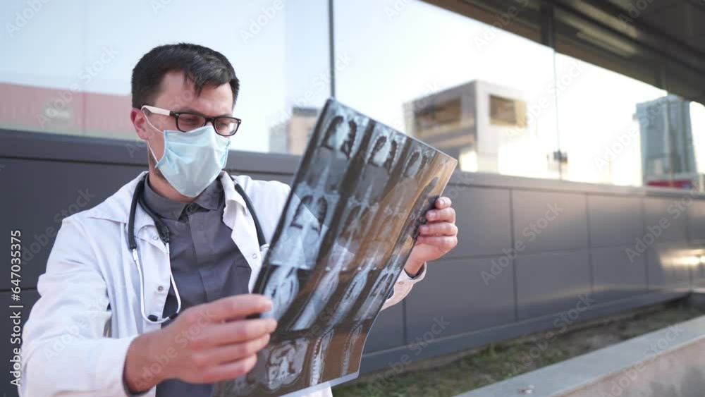 Male doctor examines x-ray of patient chest with CT scan film ...