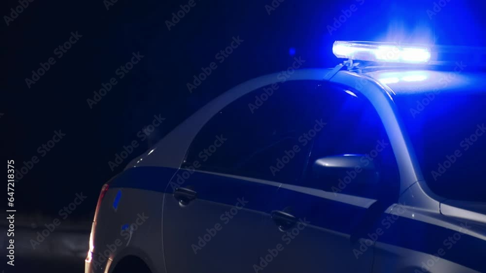 Flickering blue light flasher lightbar on police car at night street ...