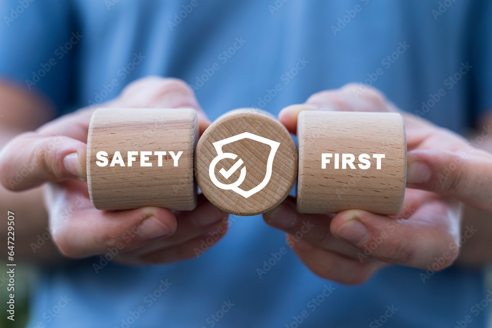 Man holding wooden cylinders with inscription: SAFETY FIRST. Safety ...