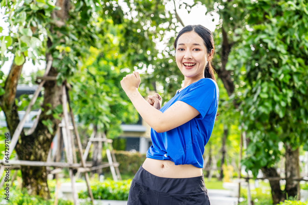Strong athletic asian woman stretching warming up before running. Fit sport girl stretching her ...