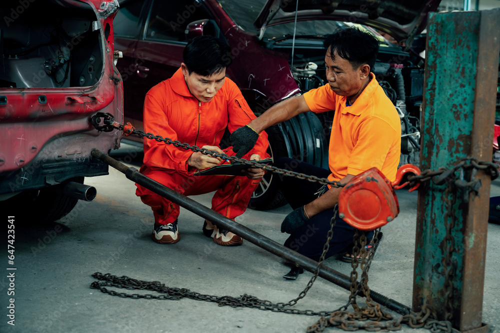 Mechanic testing strength and reliability of chain hoist for car towing ...