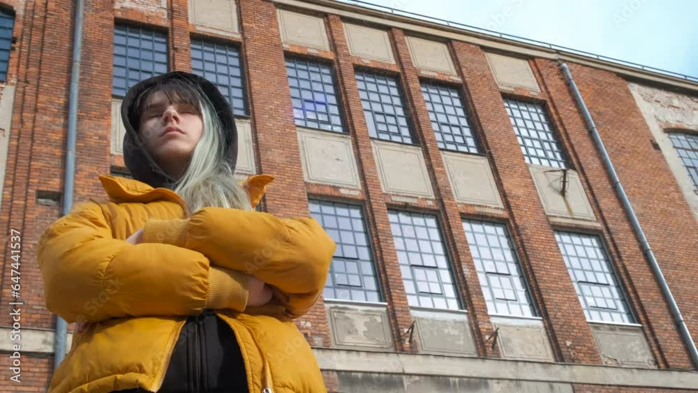 Homeless teen by brick building. A homeless teen girl stand against ...