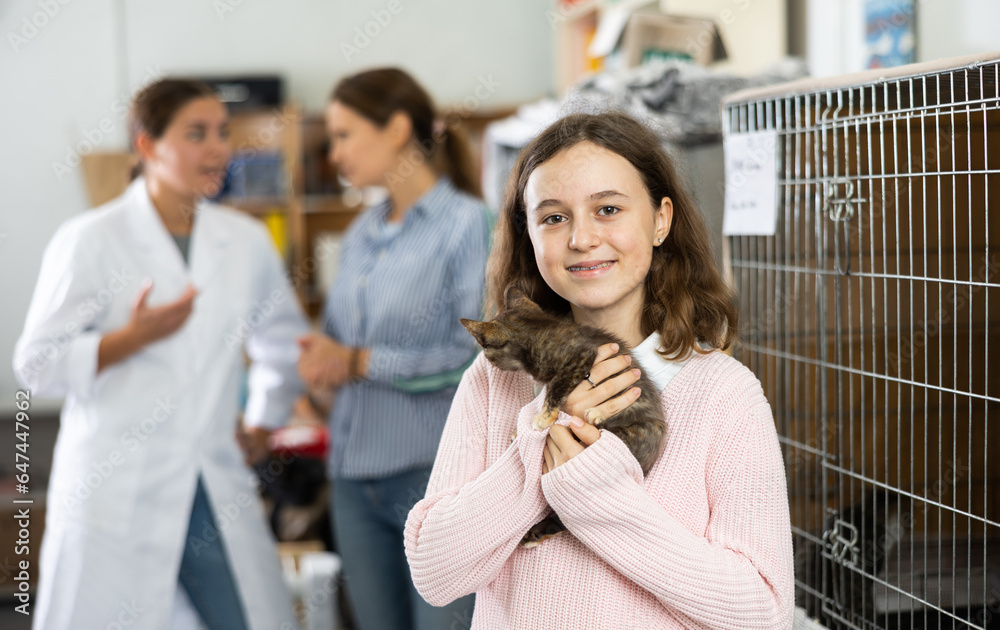 Cheerful cute tween girl standing near cages for homeless animals in ...