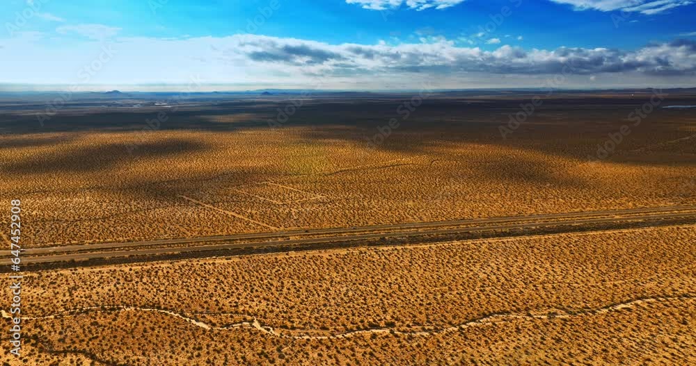 Endless scenery of the dry desert in California. Massive clouds shading ...