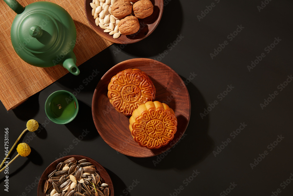 Delicious mooncakes, set of tea and dry nuts on black background. Mid ...