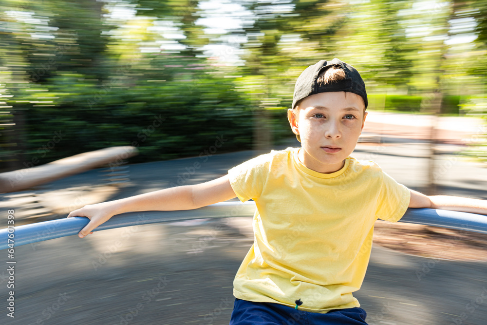 Boy spinning around on a carousel in a park in summer, Georgia Stock ...