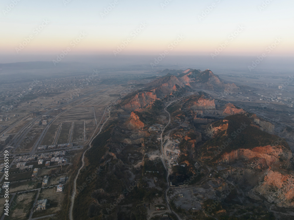 Aerial view of hills during sunrise in residential area B-17 in ...