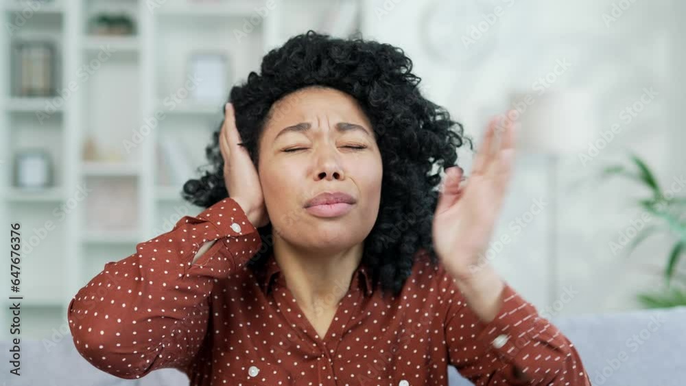 Young african american female is suffering from extraneous noise while ...