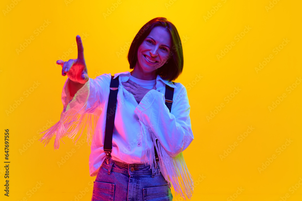 Happy, smiling woman in her 30s wearing white shirt and suspenders ...